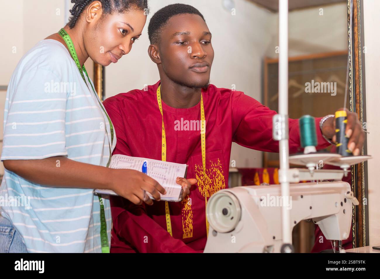 Young female trainee African-American ethnicity, learning craft from a ...