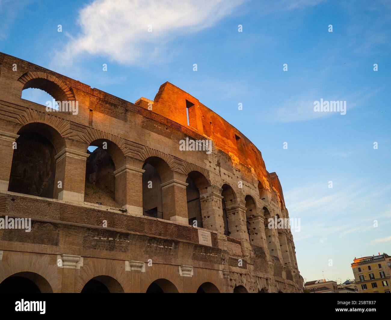 Historic Colosseum in Rome illuminated by warm golden light against a ...