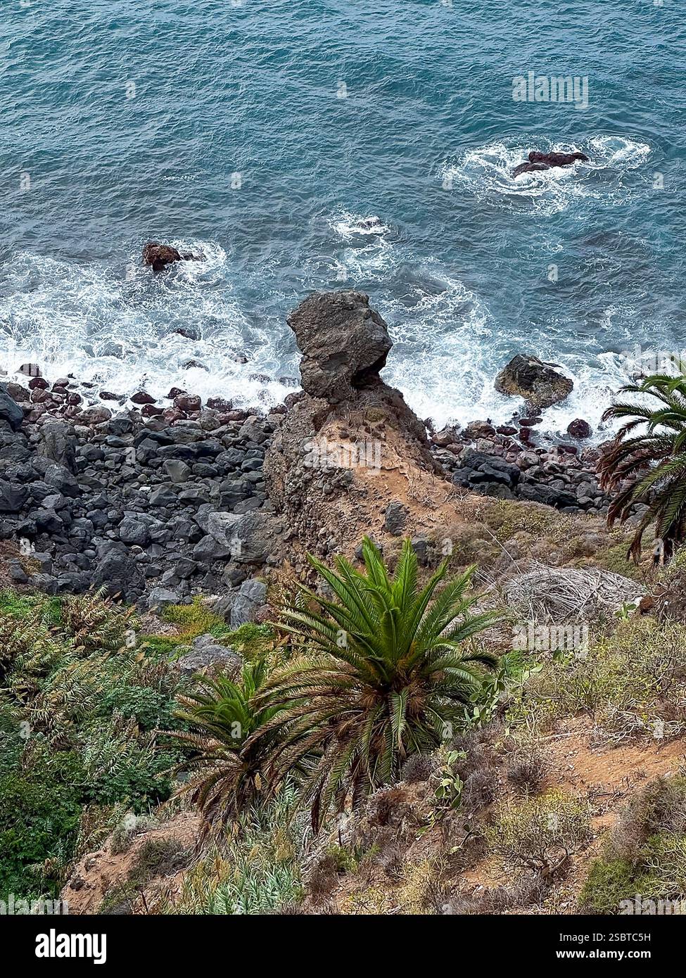 A rugged coastal cliff in Tenerife, Spain, featuring a striking rock ...