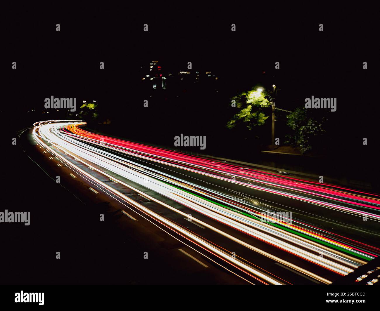 A curving highway at night captured with long-exposure photography ...