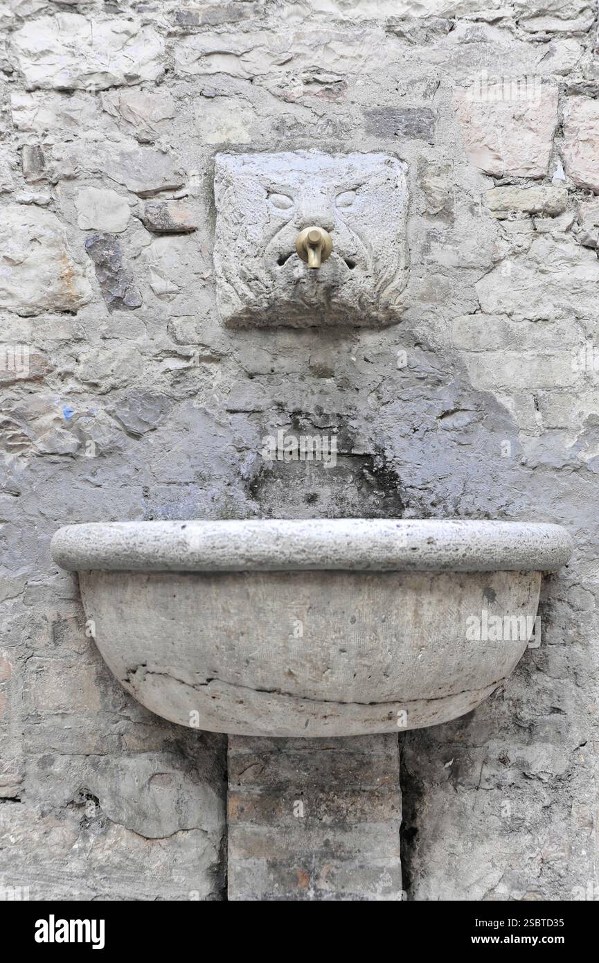 Stone fountain with inlaid tap on a wall, Assisi, Umbria, Italy, Europe ...