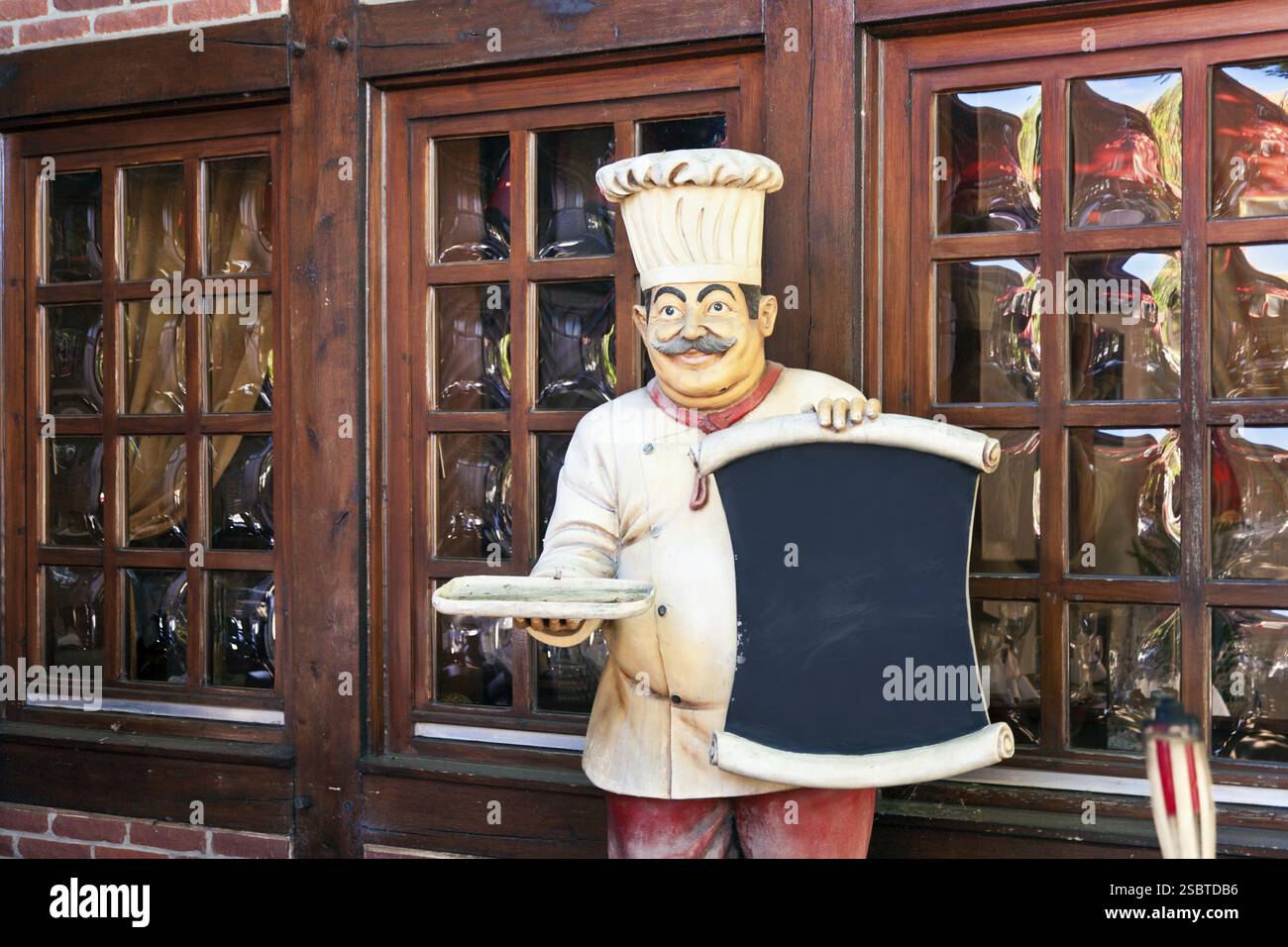 Menu board with statue of chef outdoors Stock Photo - Alamy