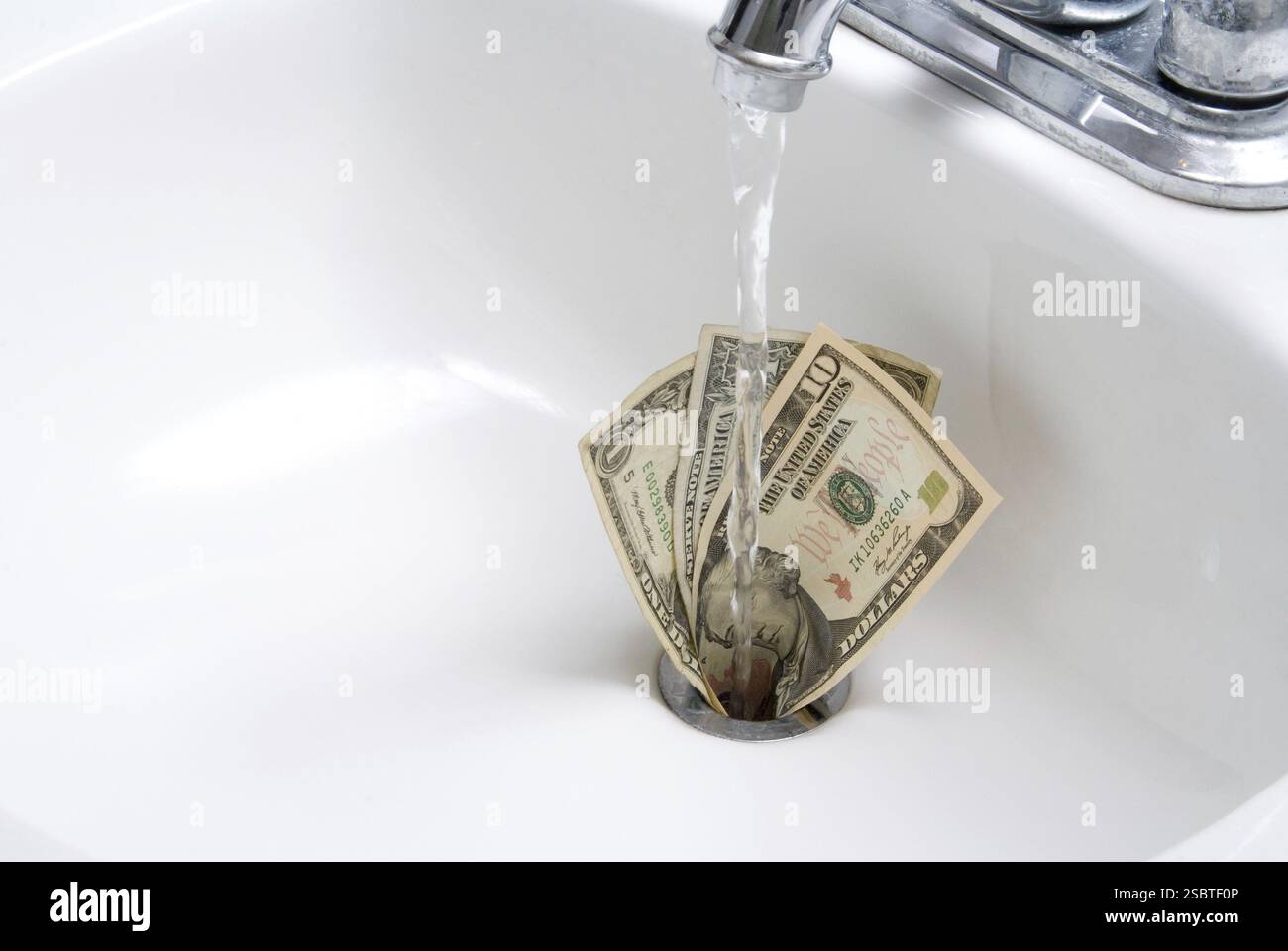 The timeless concept of Money Down the Drain Stock Photo - Alamy