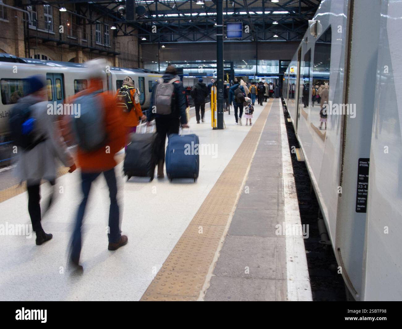 Motion blurred passengers getting off a train at Kings Cross Railway ...