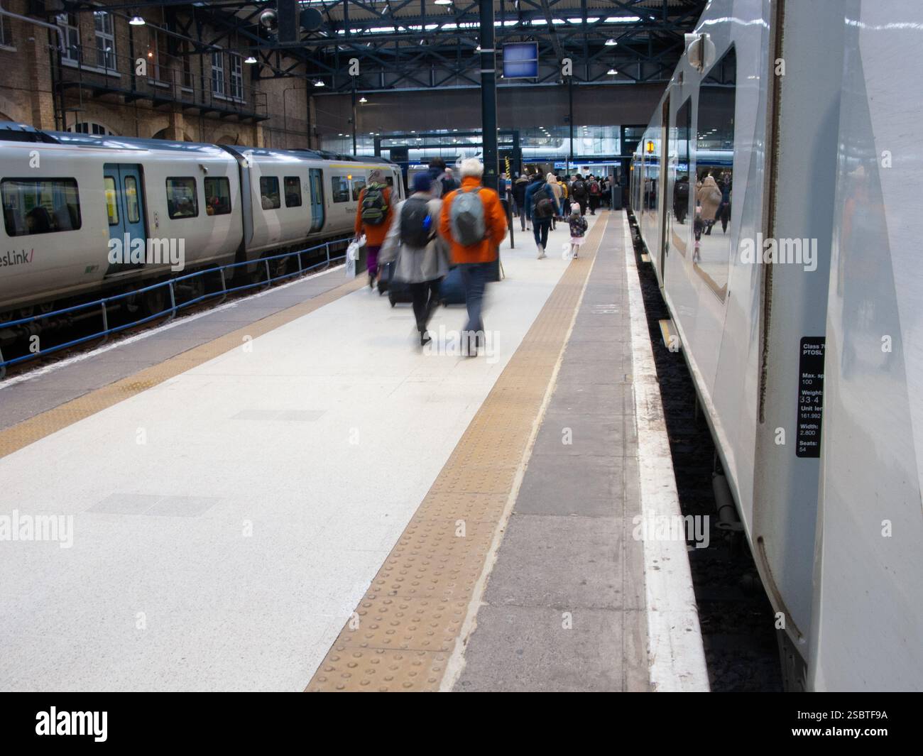 Motion blurred passengers getting off a train at Kings Cross Railway ...