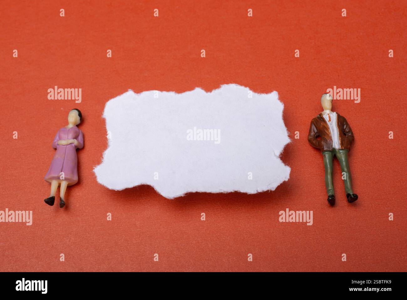 Human figurine beside white torn paper Stock Photo - Alamy