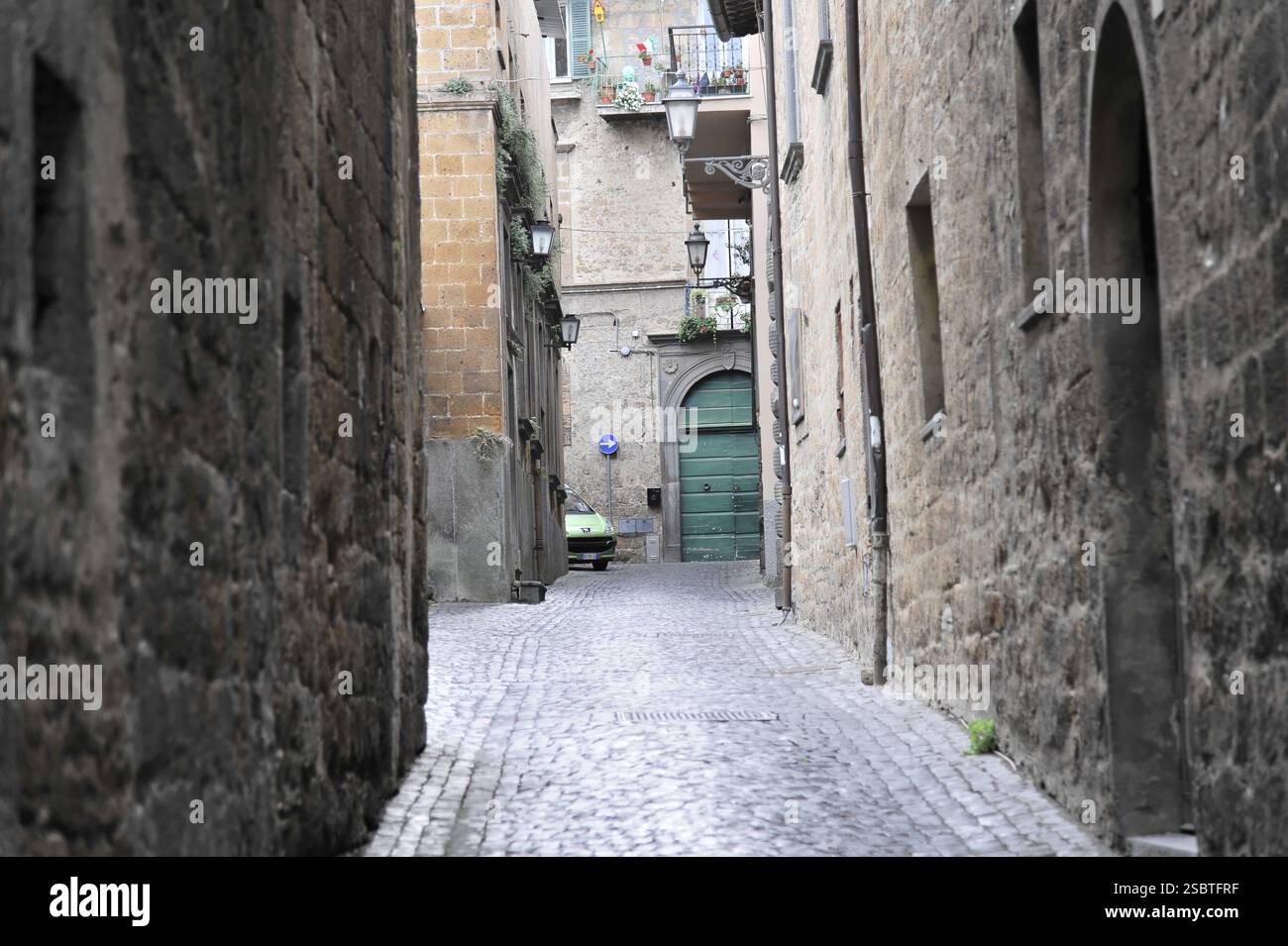Narrow cobbled alley surrounded by historic stone buildings and ...