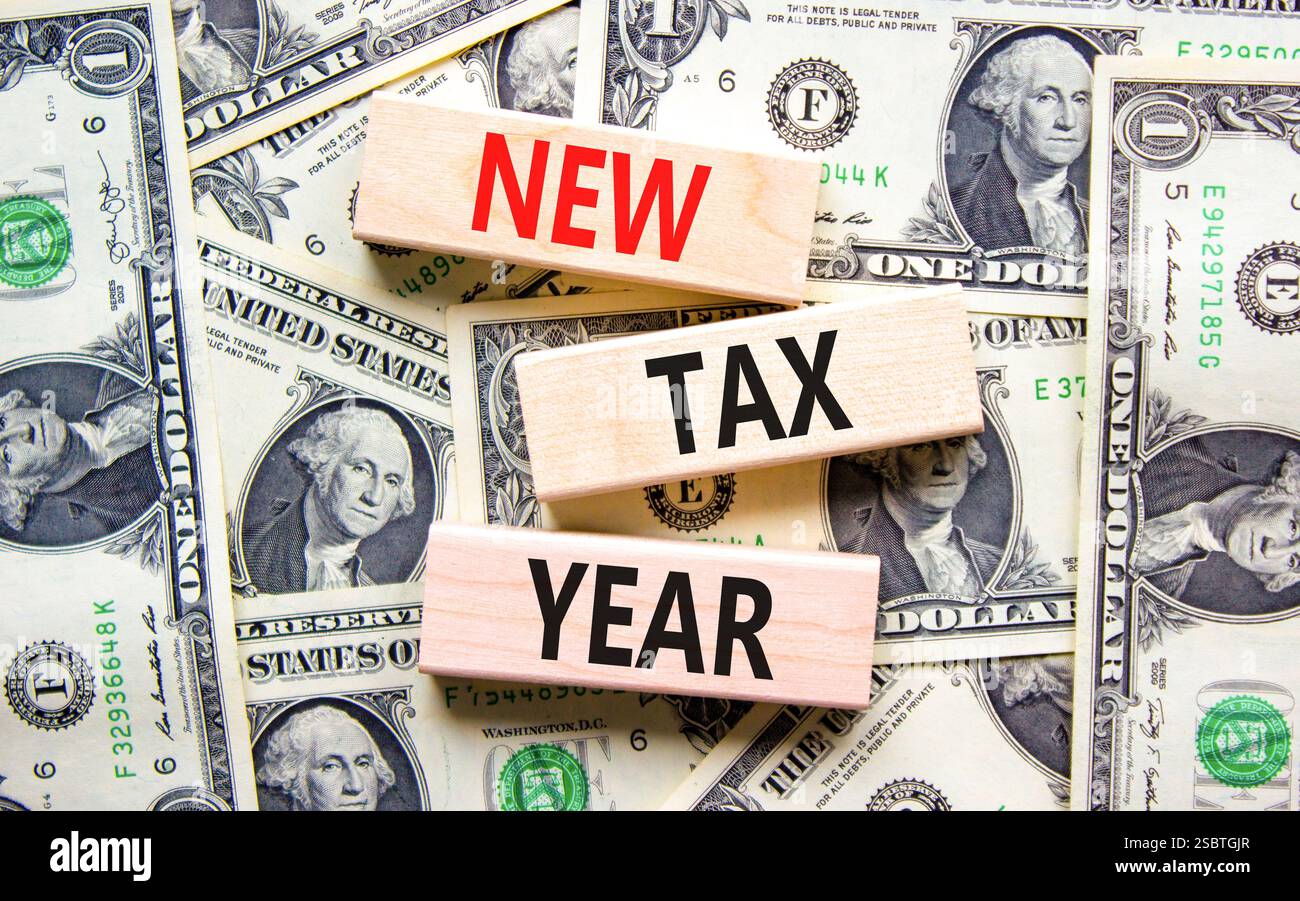 New tax year symbol. Concept words New tax year on beautiful wooden blocks. Dollar bills ...