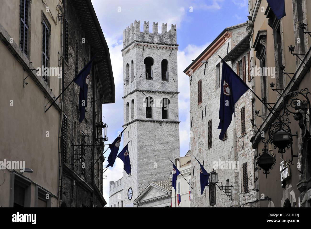 Old town alley decorated with flags, church tower of the Santa Maria ...
