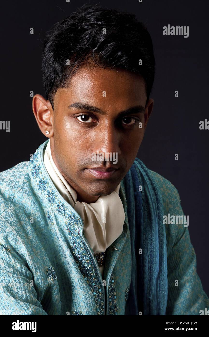 Beautiful face of an Indian Hindu young man with earring wearing blue ...