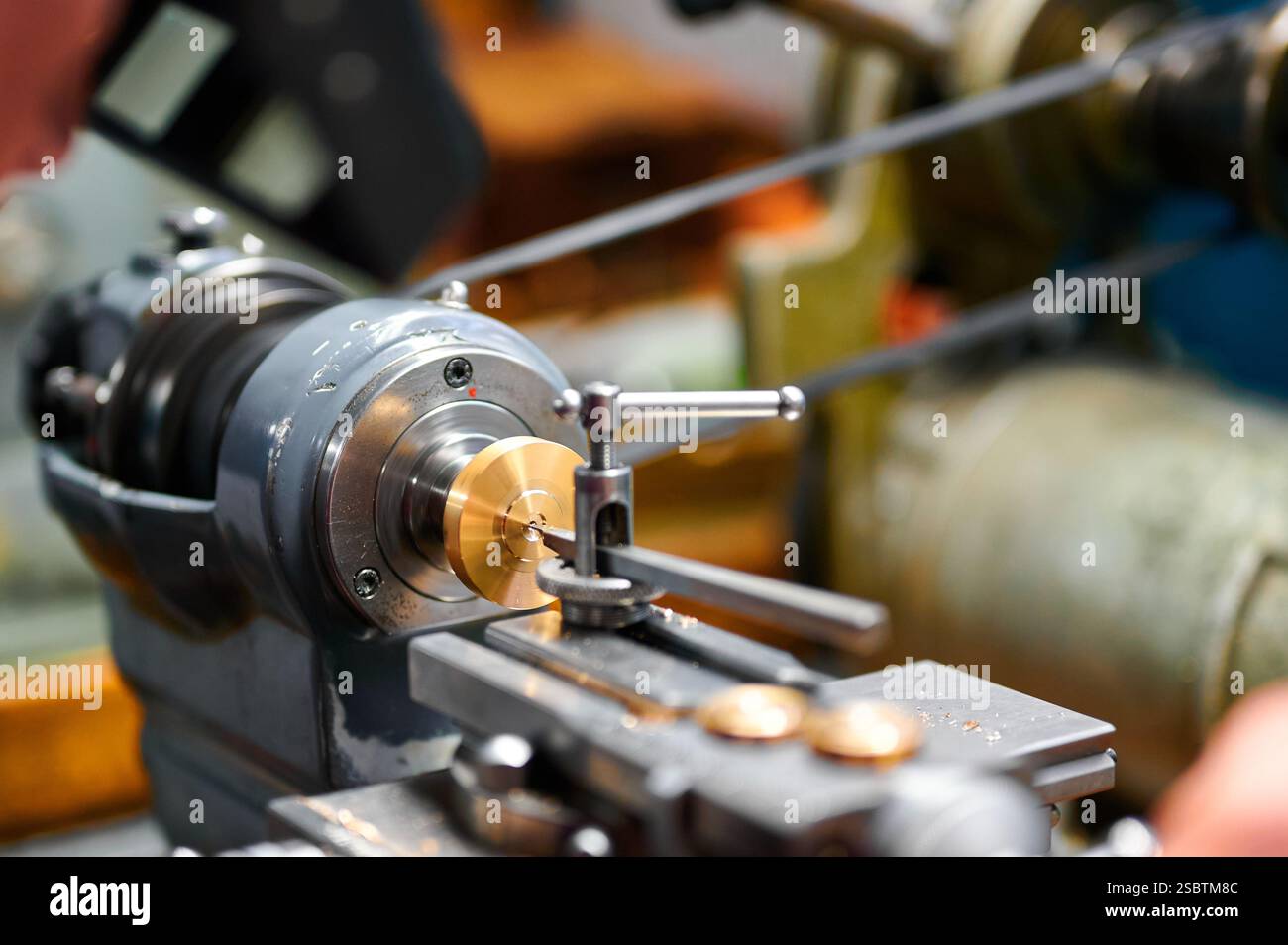 Crafting precision components on a small lathe in a bustling workshop ...
