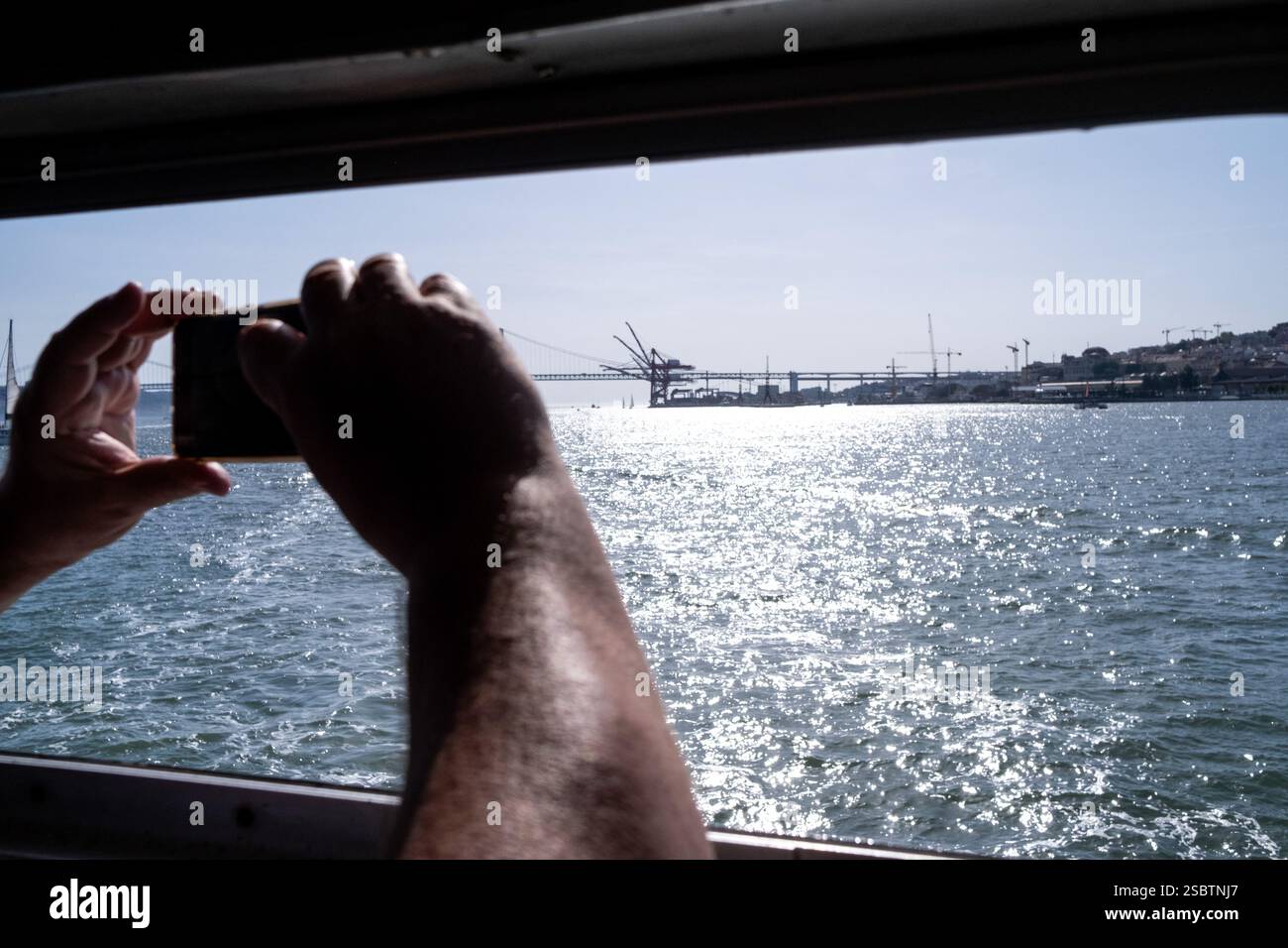 Tourist taking photos of the 25 April Bridge (in Portuguese Ponte 25 de ...