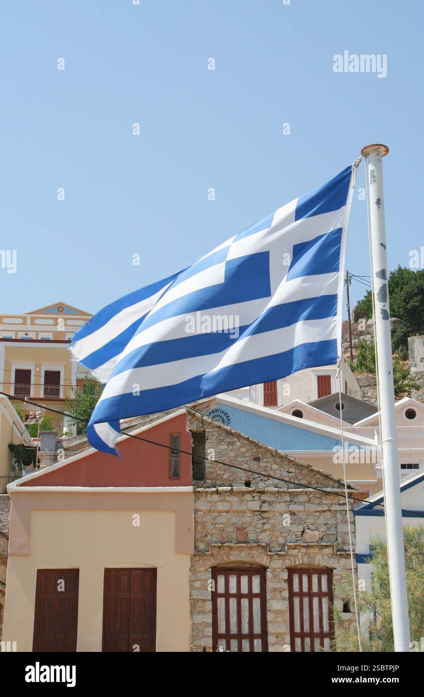 Greek flag flying in the air with Traditional Greek Buildings ...