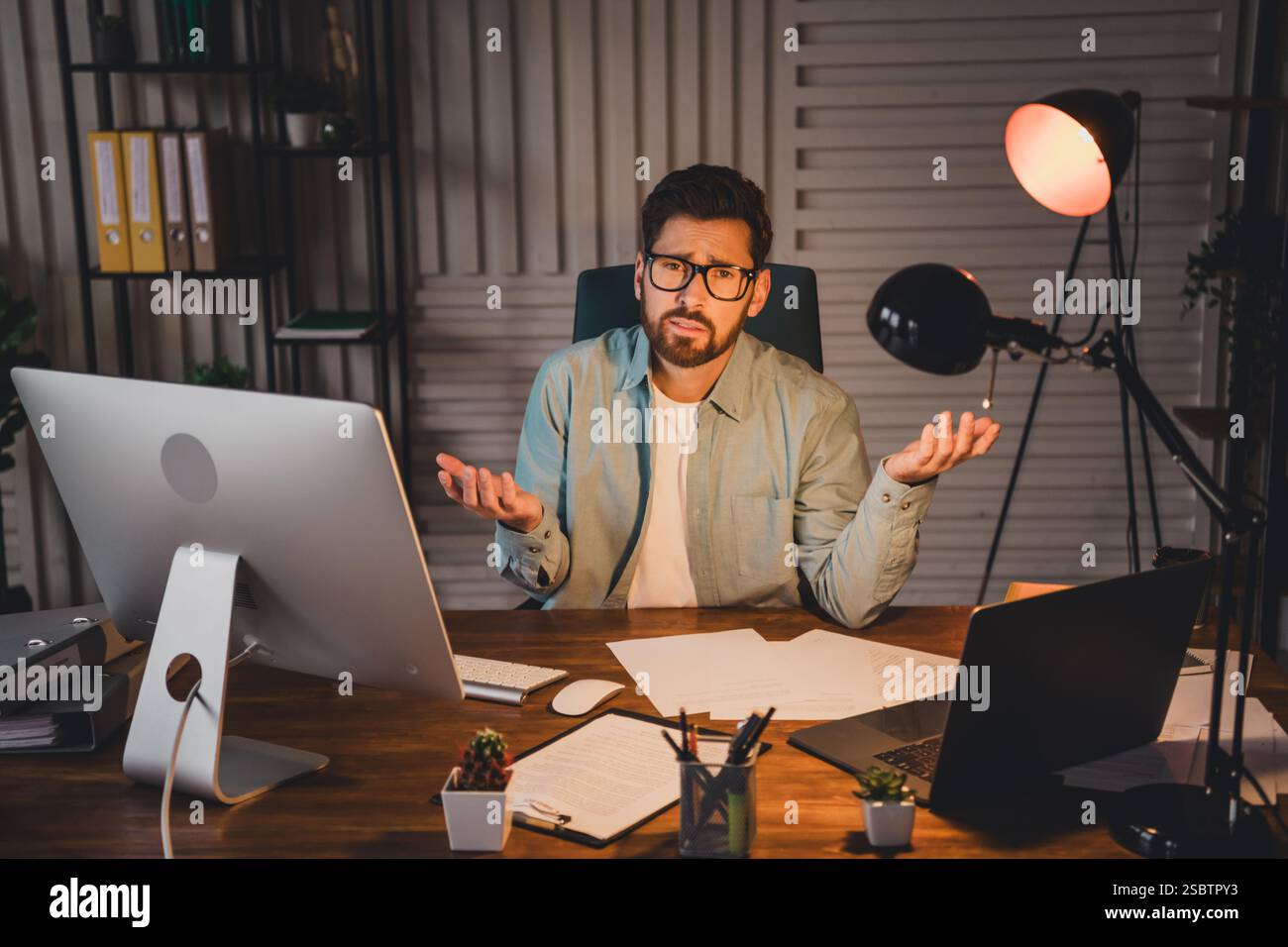 Frustrated young man at his desk in a stylish office interior working ...