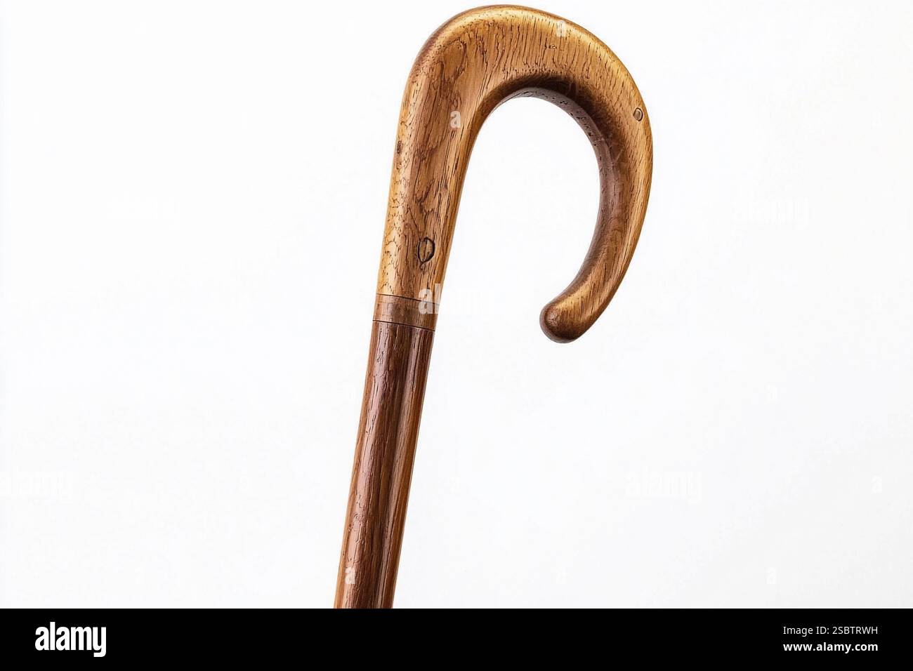 A beautifully crafted wooden cane showcases its unique curved handle ...