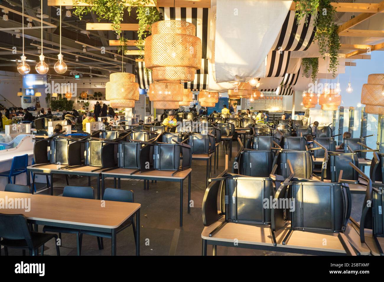 dining tables and chairs with ceiling lights and decorative rolls hung ...