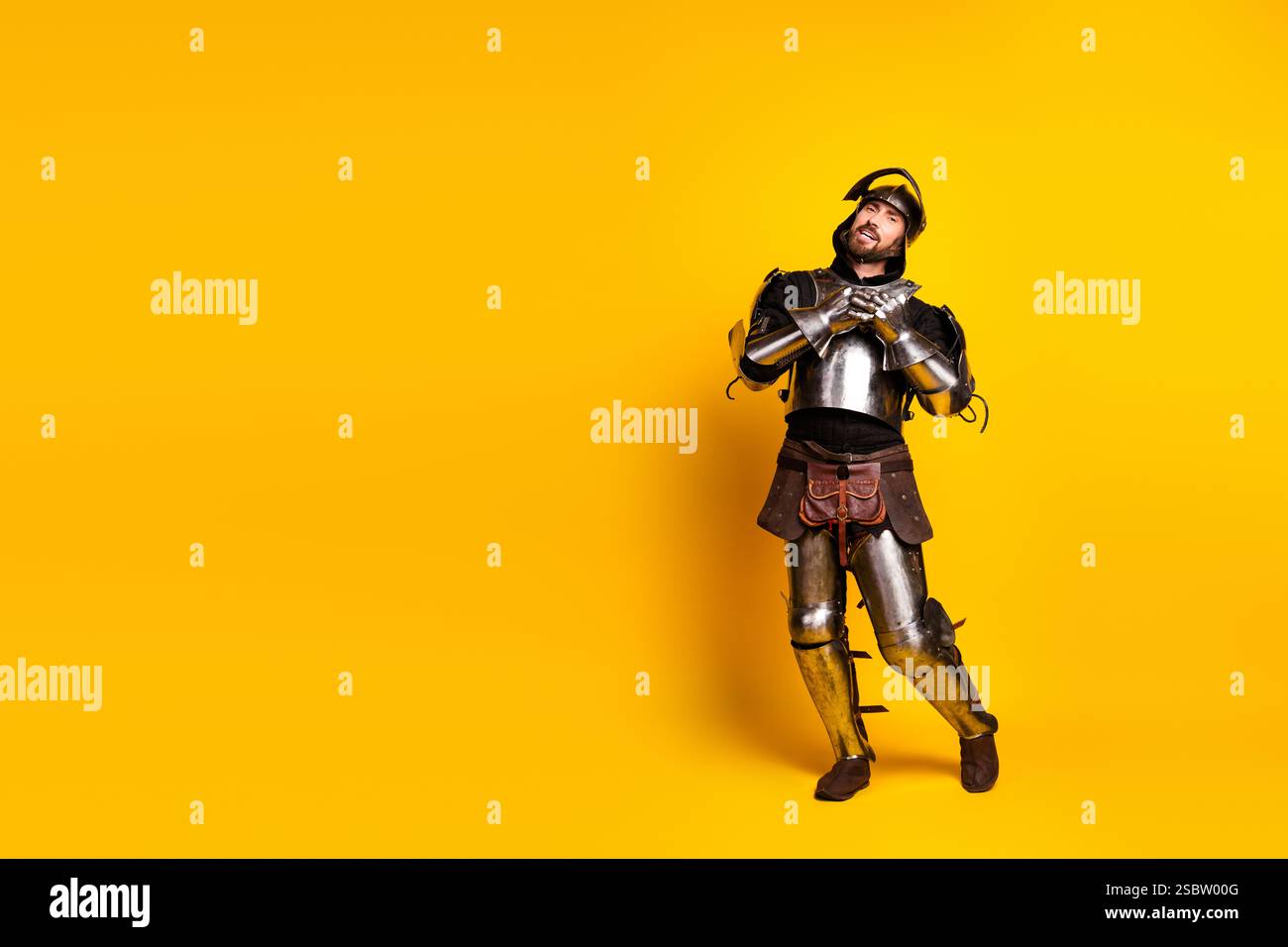 Knight in shining armor posing on vibrant yellow background showcasing ...