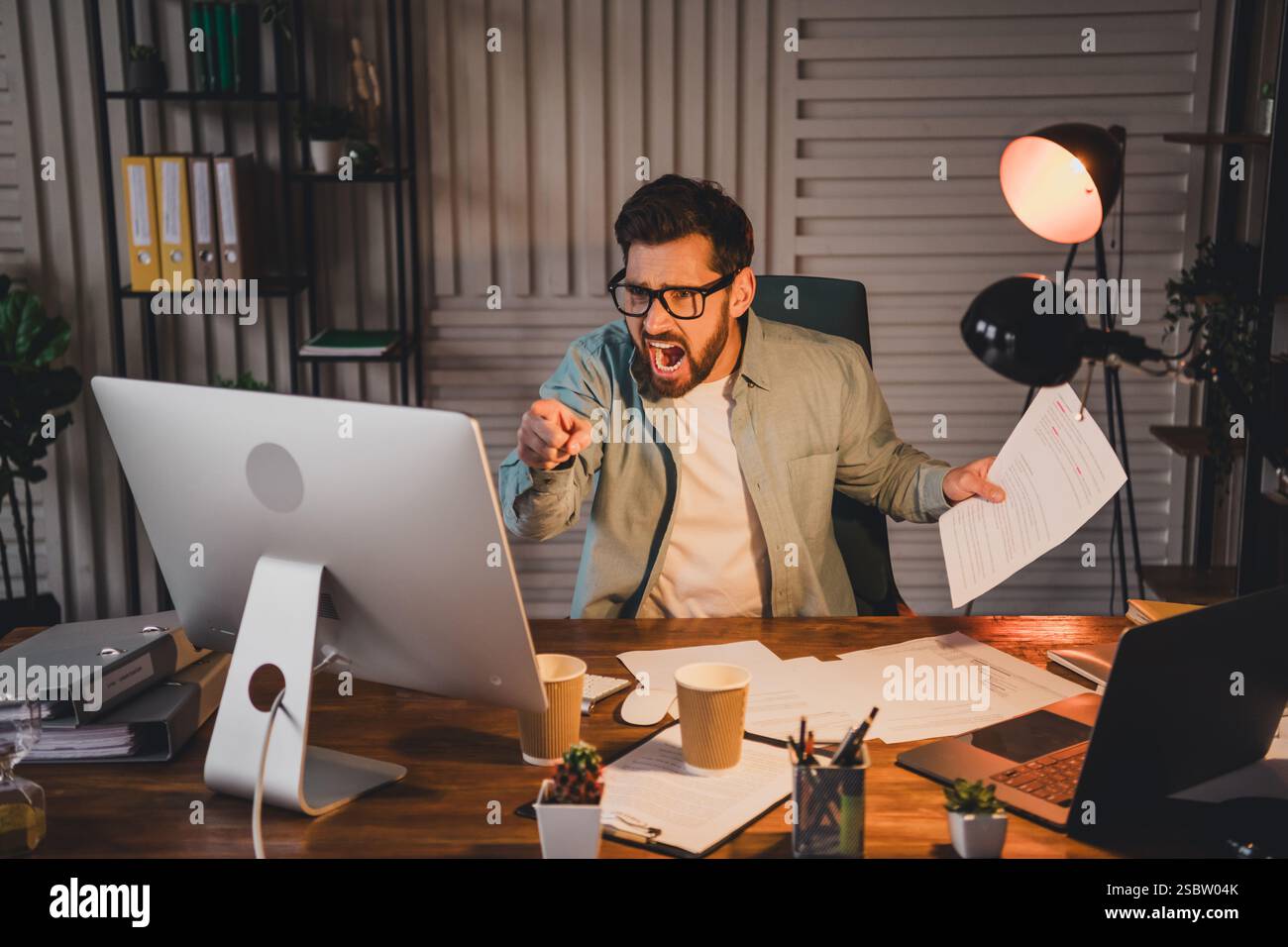 Frustrated businessman in a modern office expressing emotion towards ...