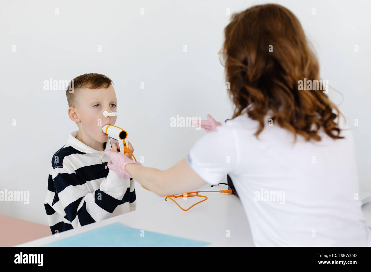 Boy testing breathing function by spirometry in doctors office ...