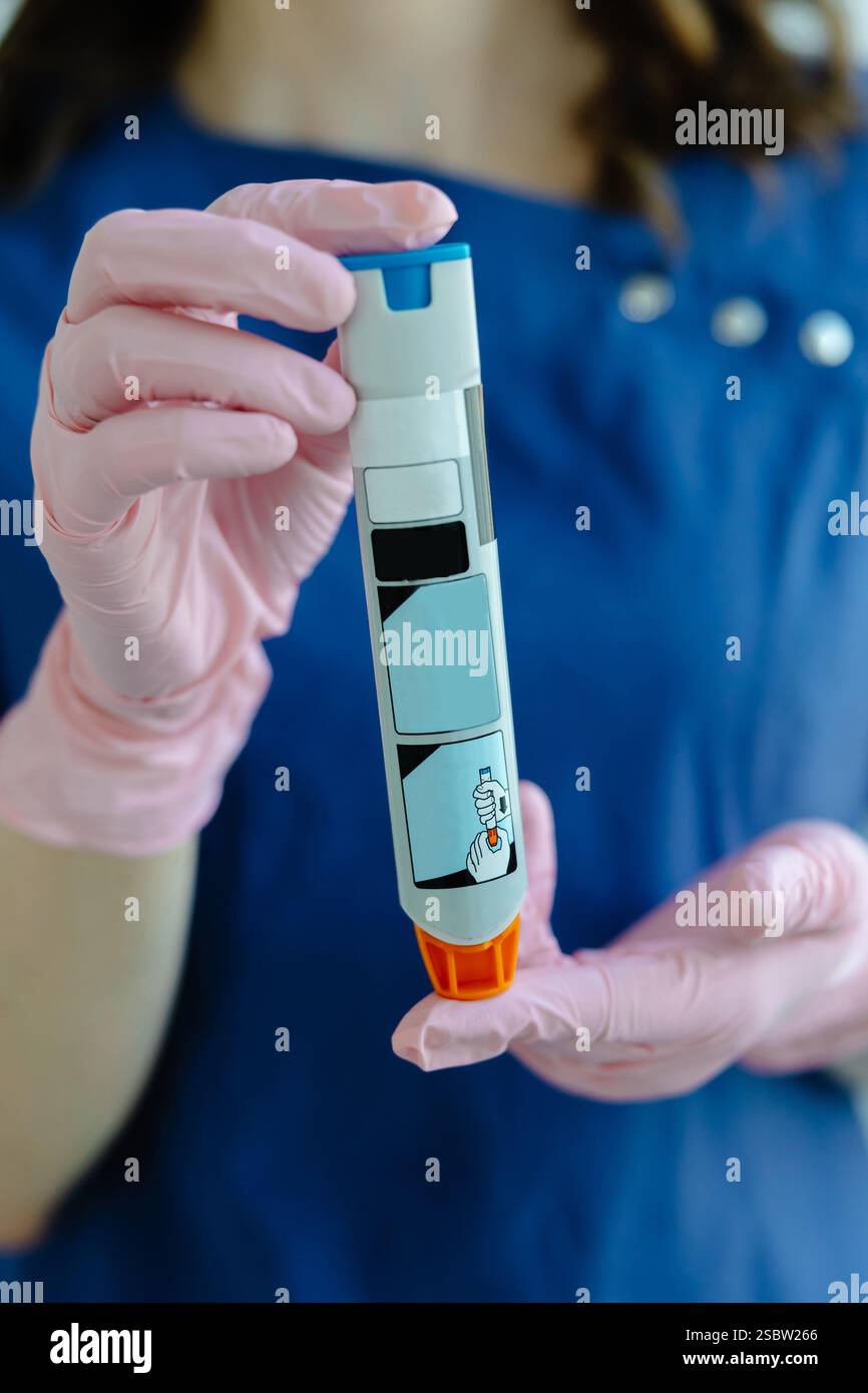 Doctor is demonstrating auto-injector syringe as an emergency treatment ...