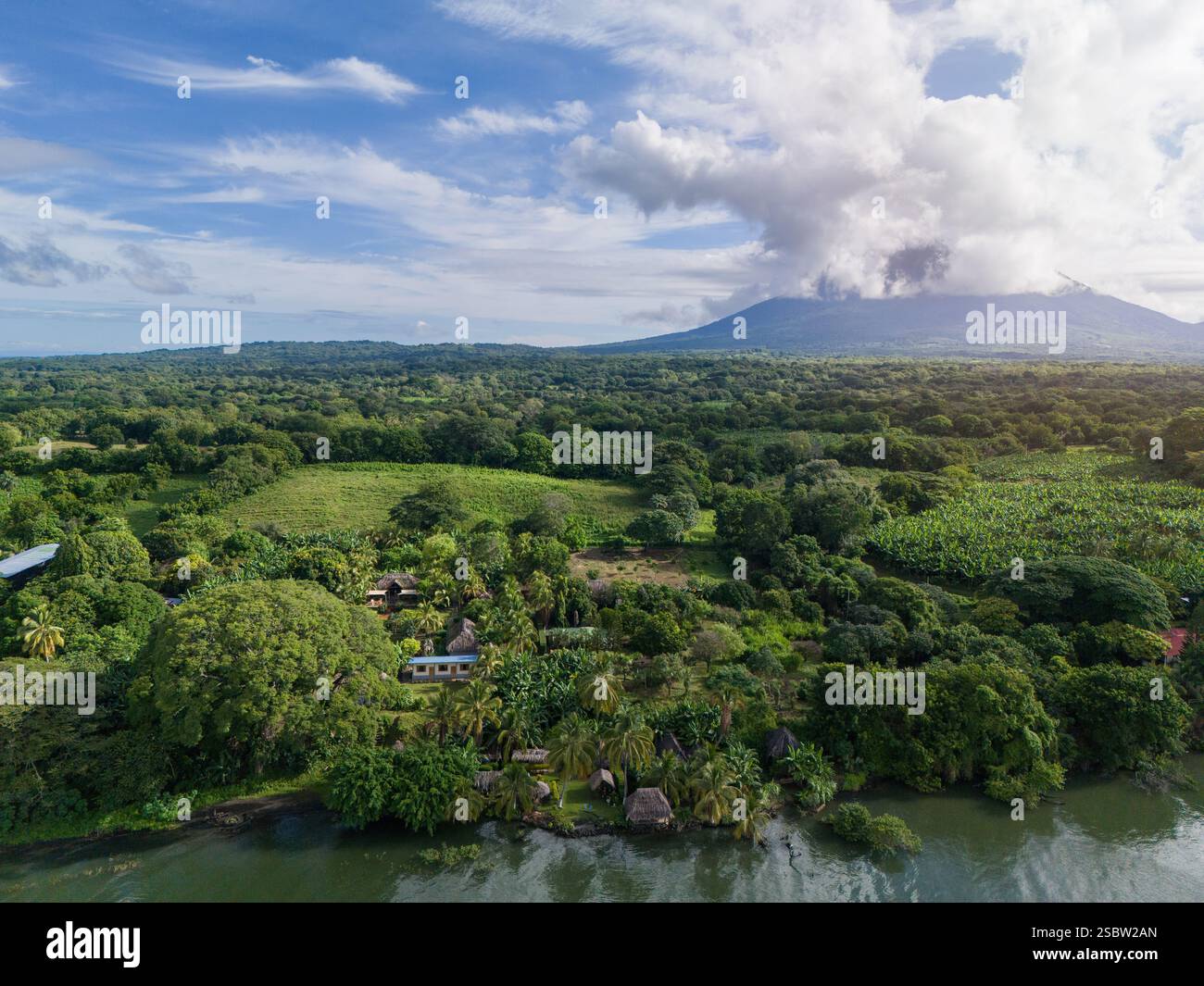 Expansive view features volcano rising above verdant fields and ...