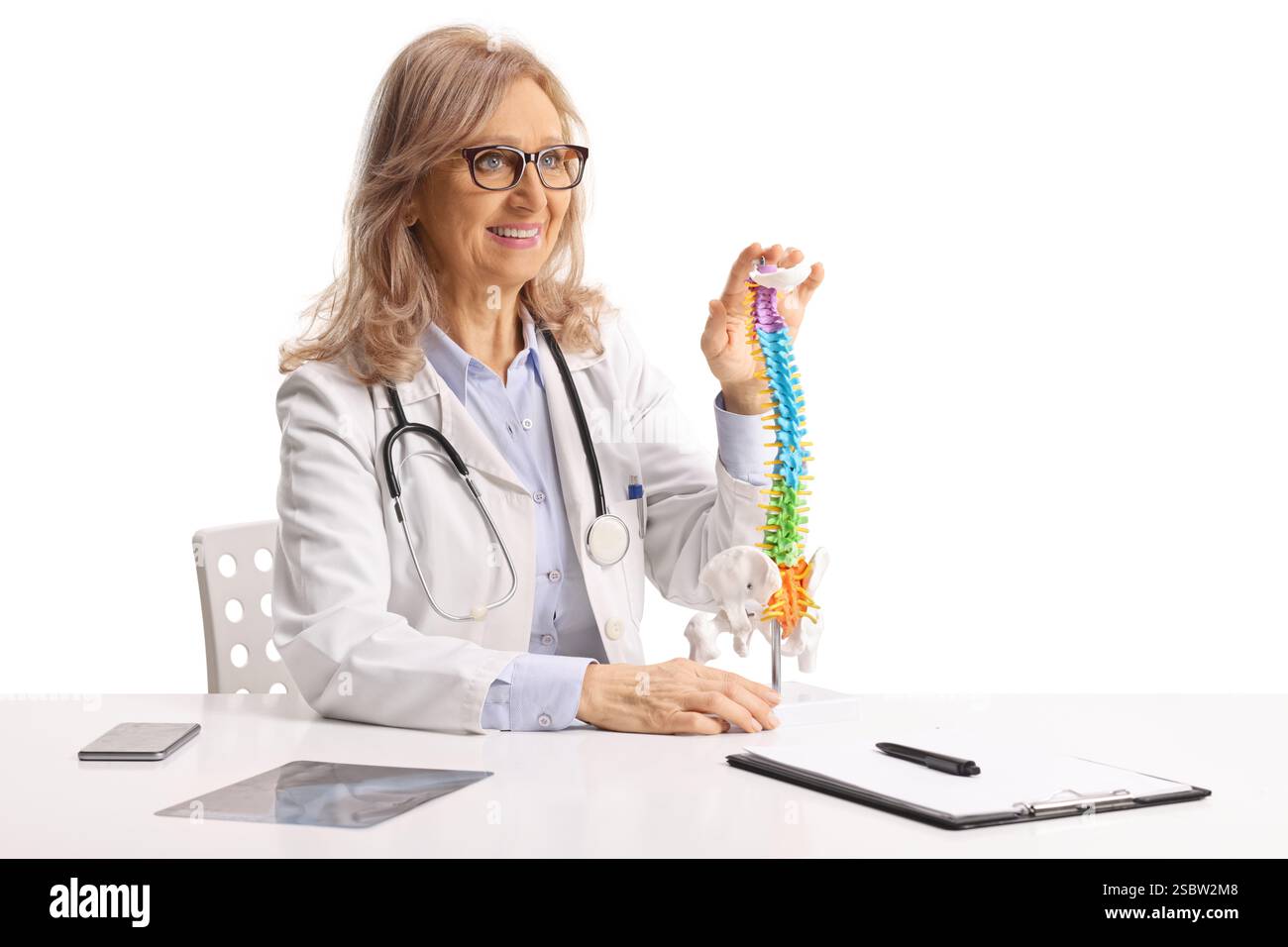 Female doctor sitting with a spine model on a desk isolated on white ...