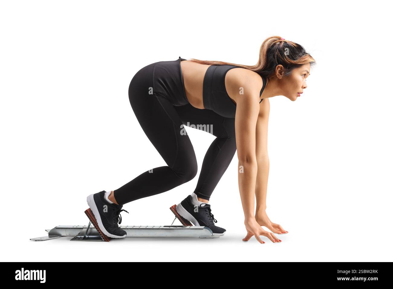 Full length profile shot of an asian woman kneeling on running start blocks isolated on white ...
