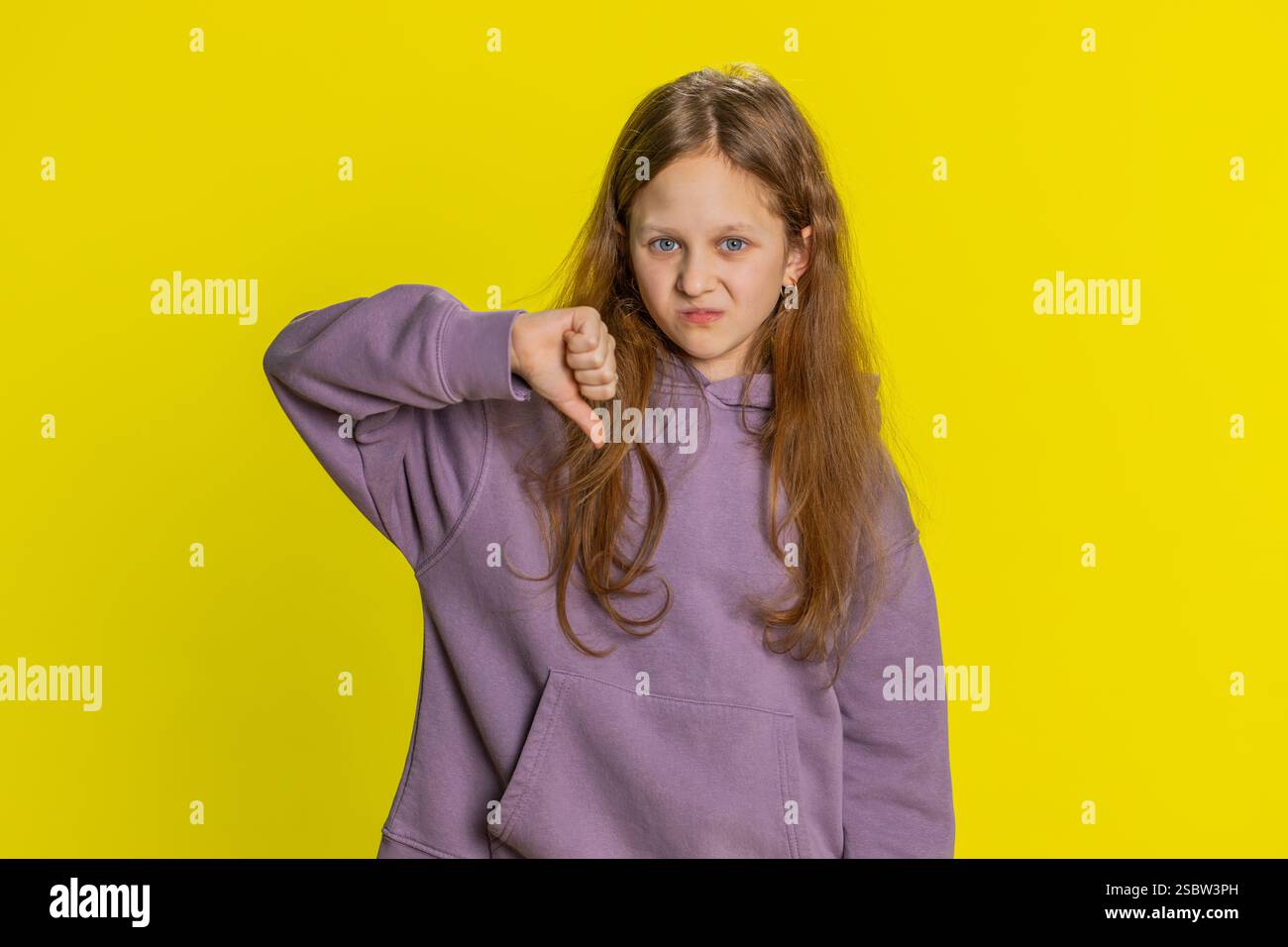 Dislike. Upset young preteen child girl kid showing thumbs down sign ...