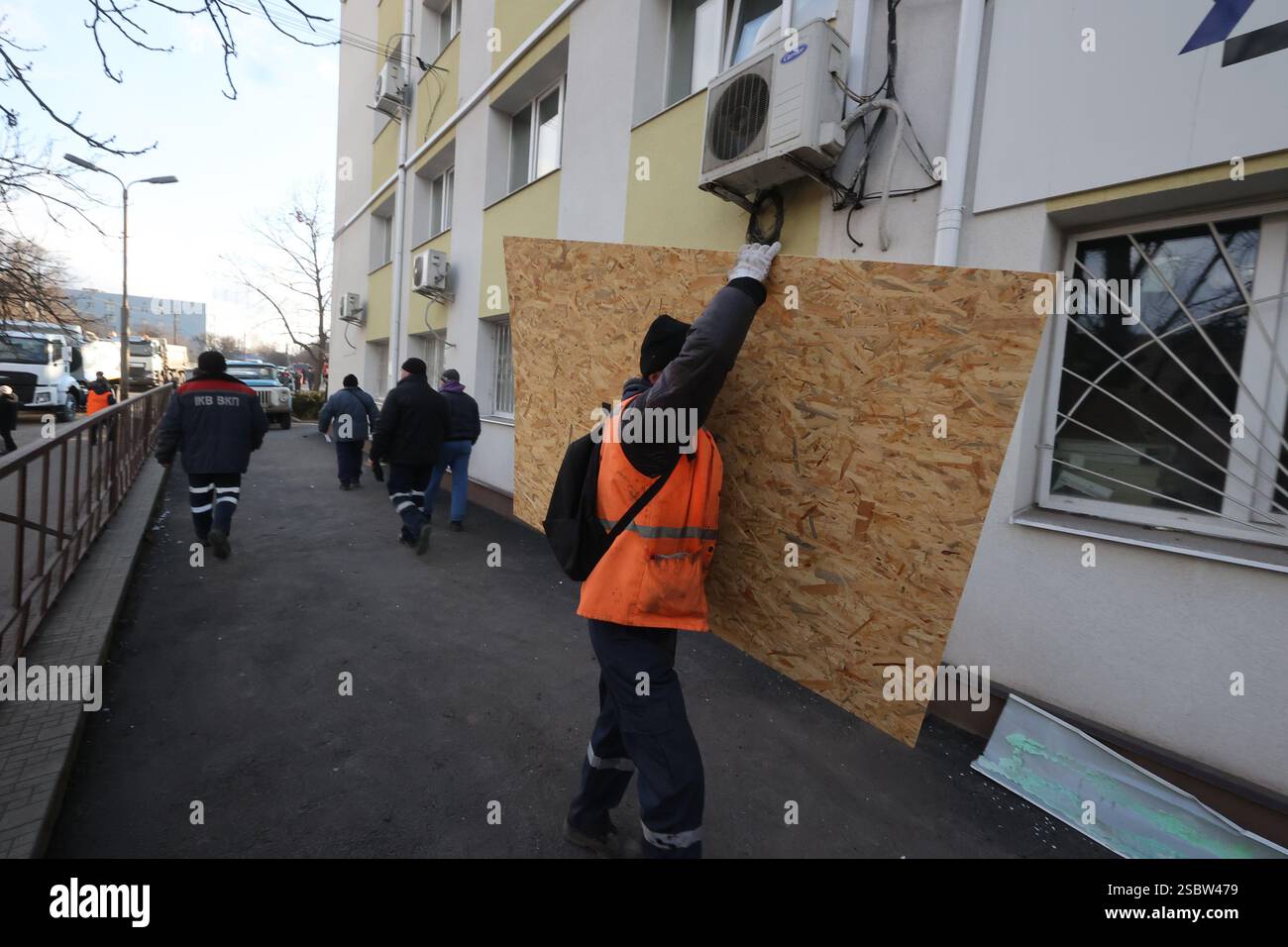 IZIUM, UKRAINE - FEBRUARY 4, 2025 - A municipal worker carries an OSB ...