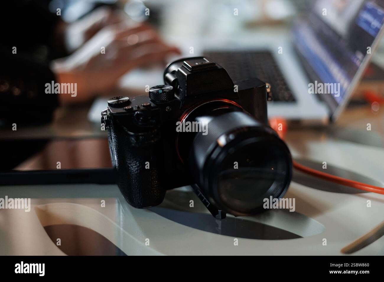Workspace with laptop and photo camera. Unrecognisable female ...