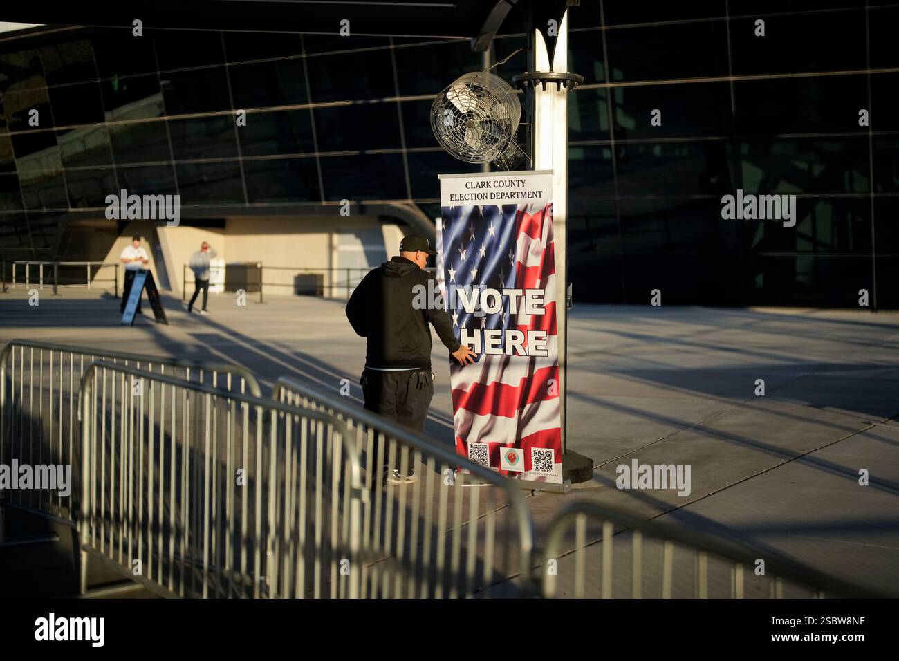 FILE - A poll worker adjusts a sign outside the Allegiant Stadium ...