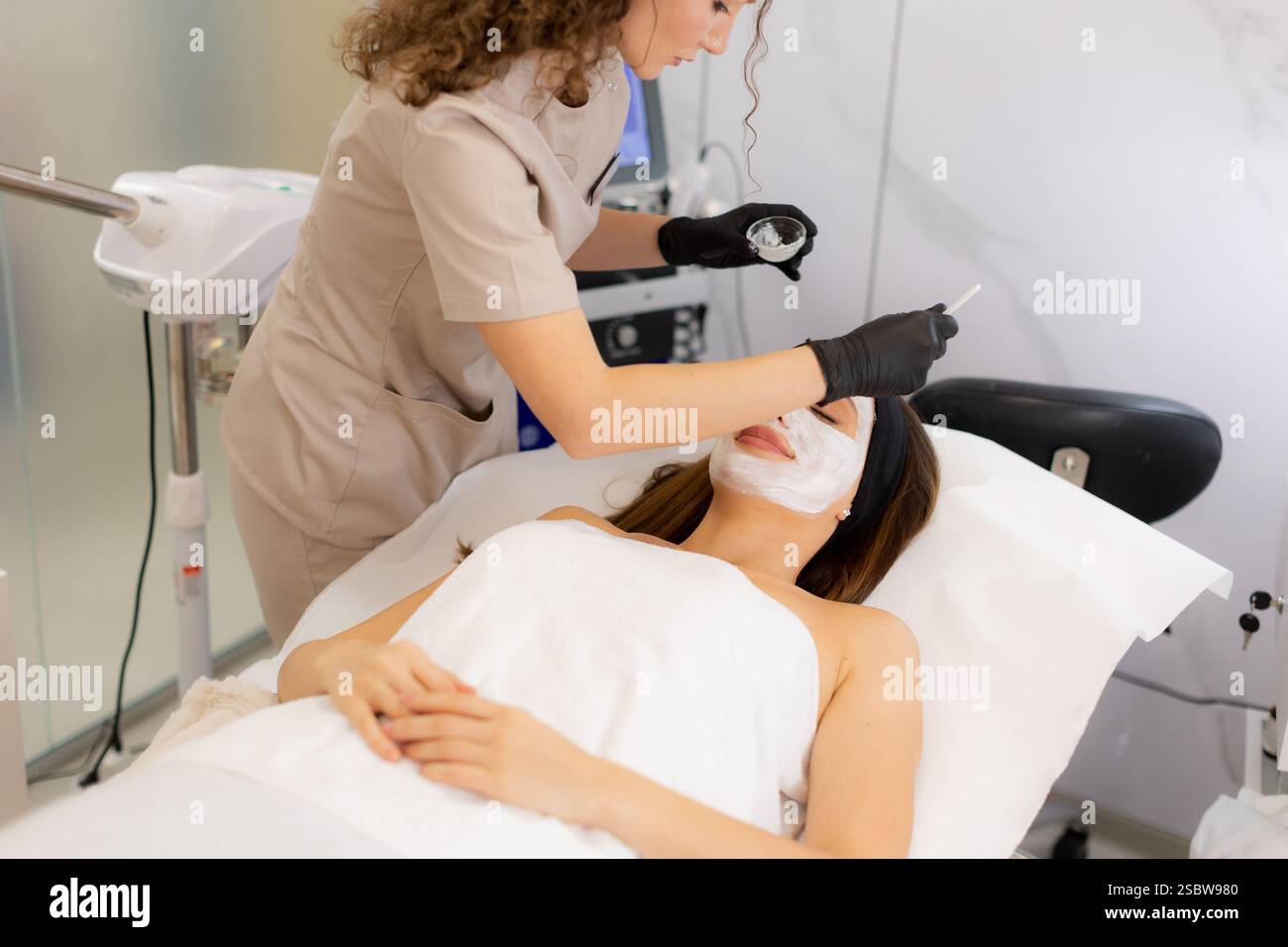 In a soothing spa setting, a patient enjoys a revitalizing facial as a ...