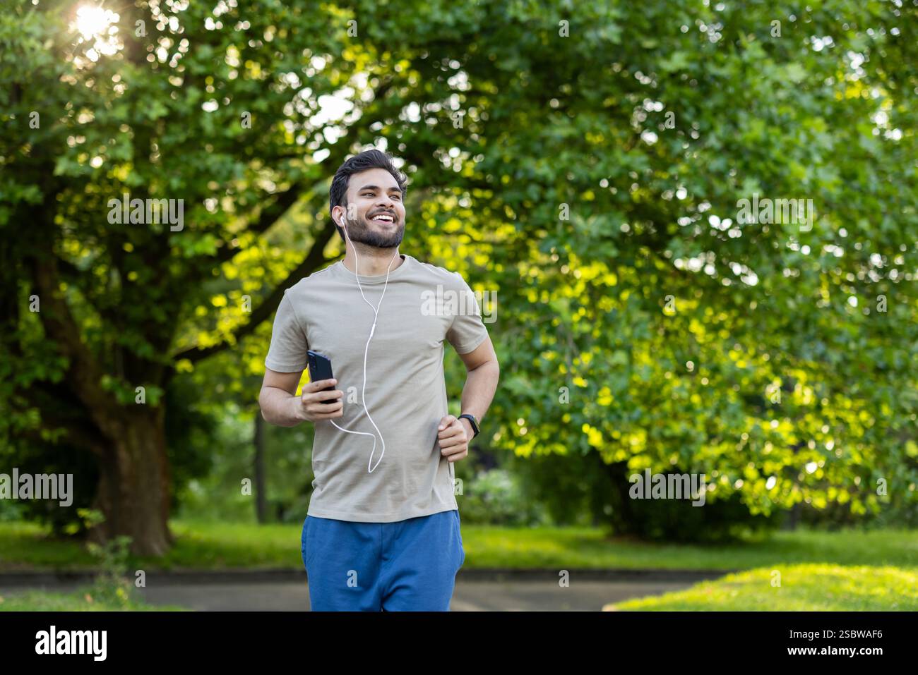Man engaged in active physical exercises and fitness in park with phone ...
