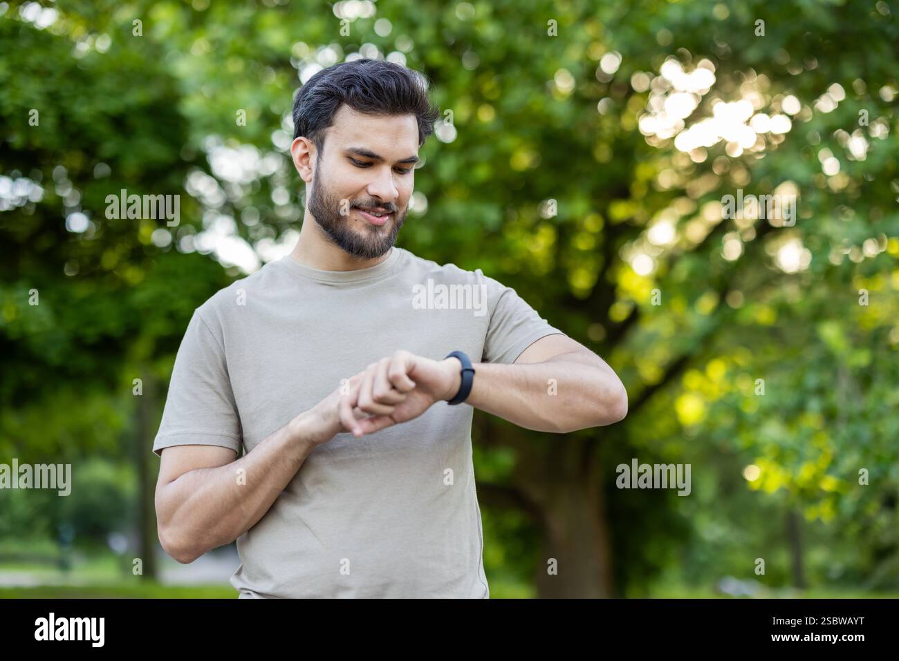 Man engaged in active physical exercises in park, checking fitness ...