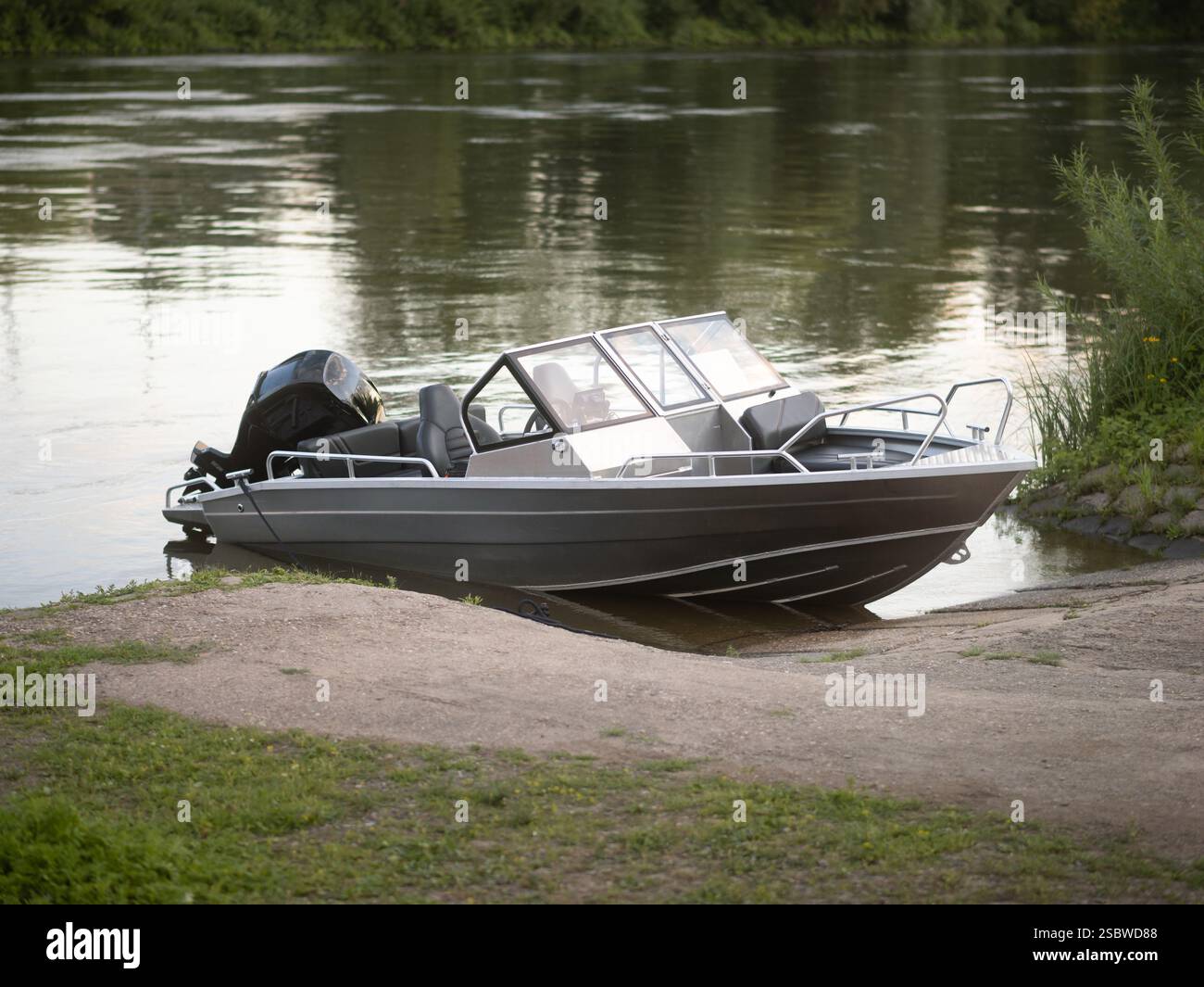 Sport boat out of aluminum at a slip place next to a river. Empty motor ...