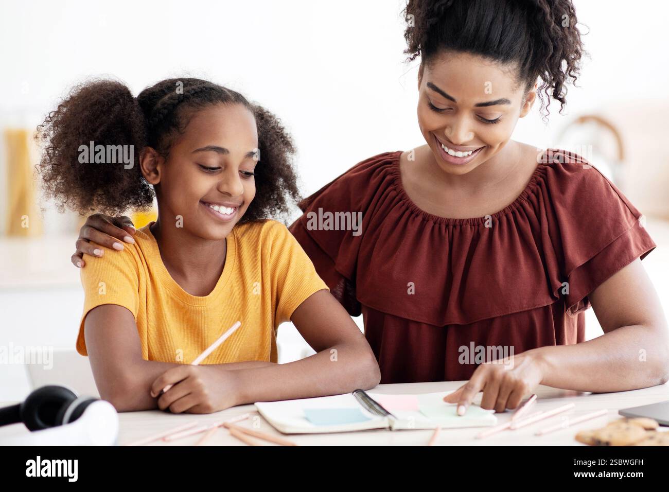 Creative black mother and daughter working on school project together ...