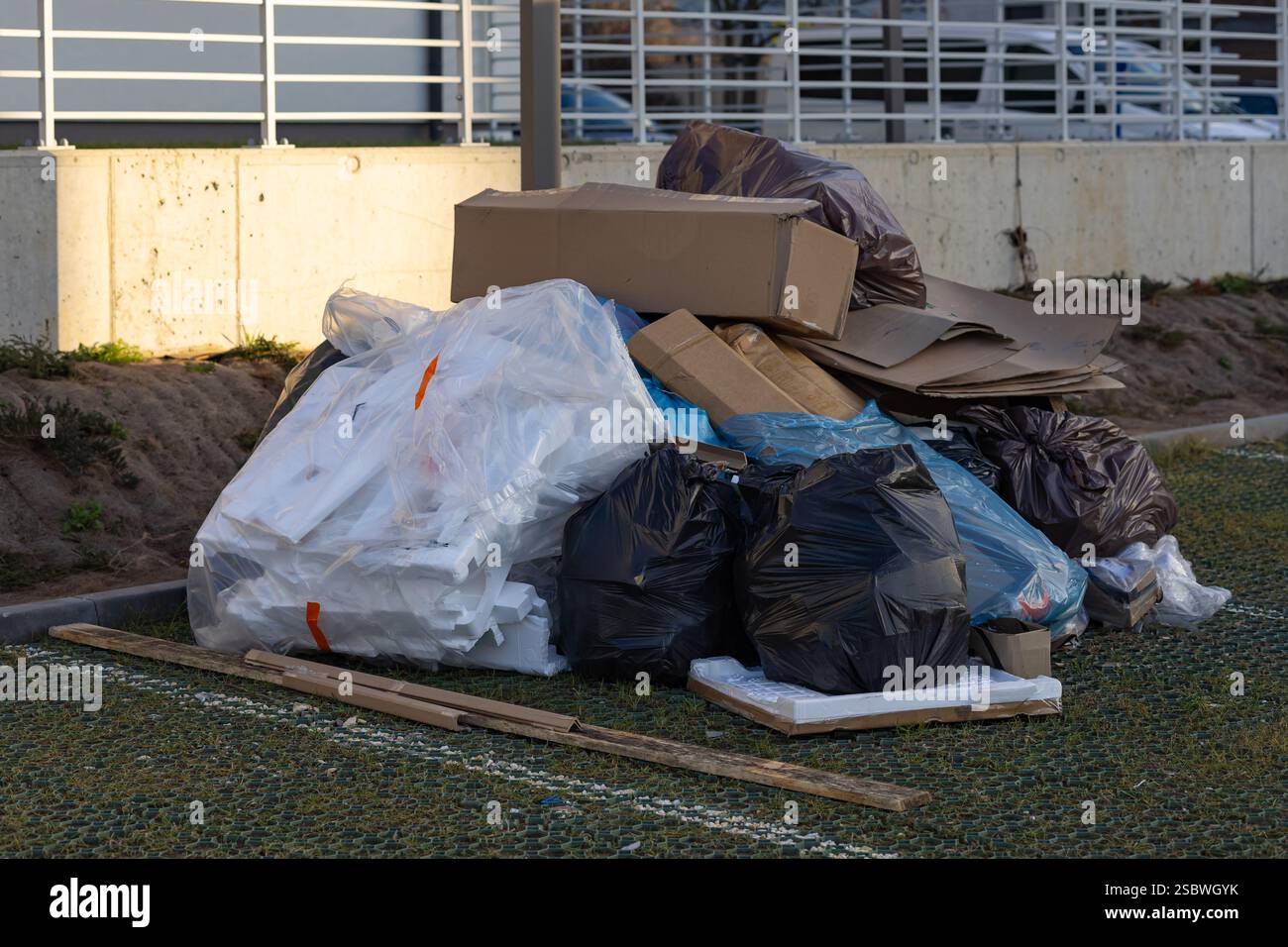 Large pile of mixed garbage with black plastic bags, torn cardboard ...
