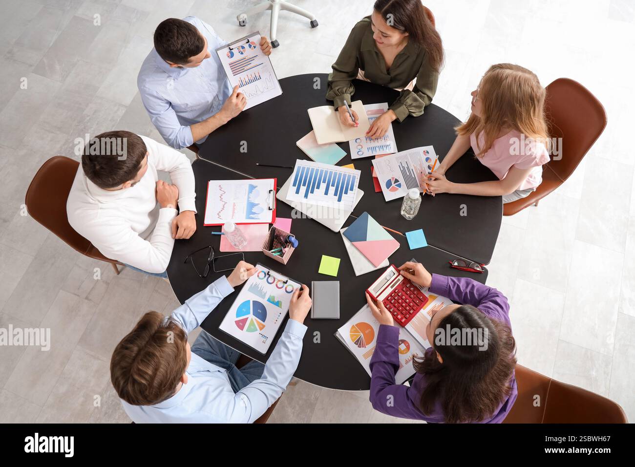 Business people with diagrams working on marketing plan at table in ...