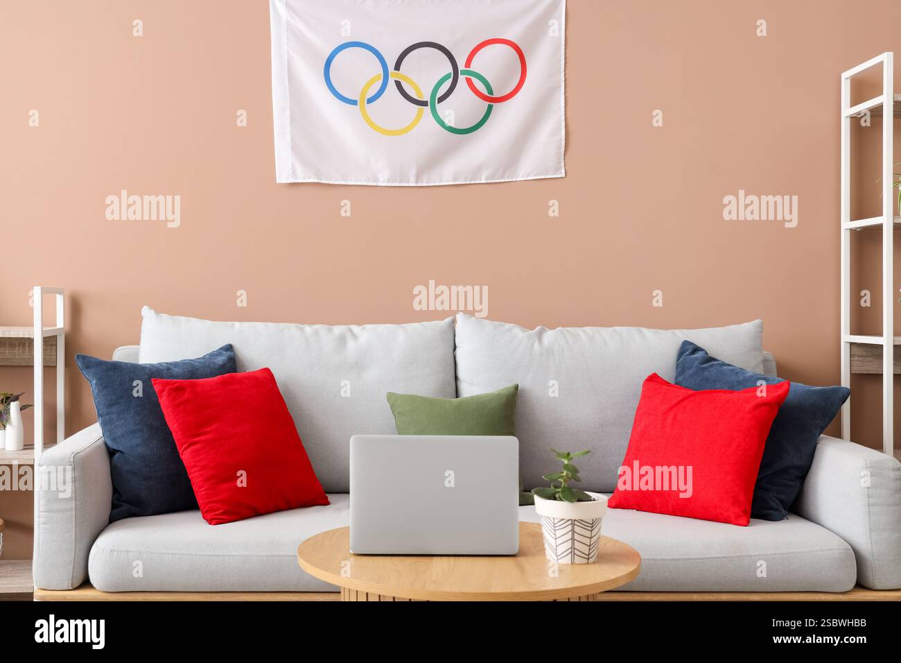 Interior of living room with grey sofa, laptop on coffee table and ...