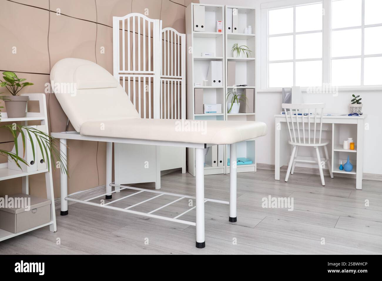 Interior of medical office with couch, doctor's workplace and folding ...