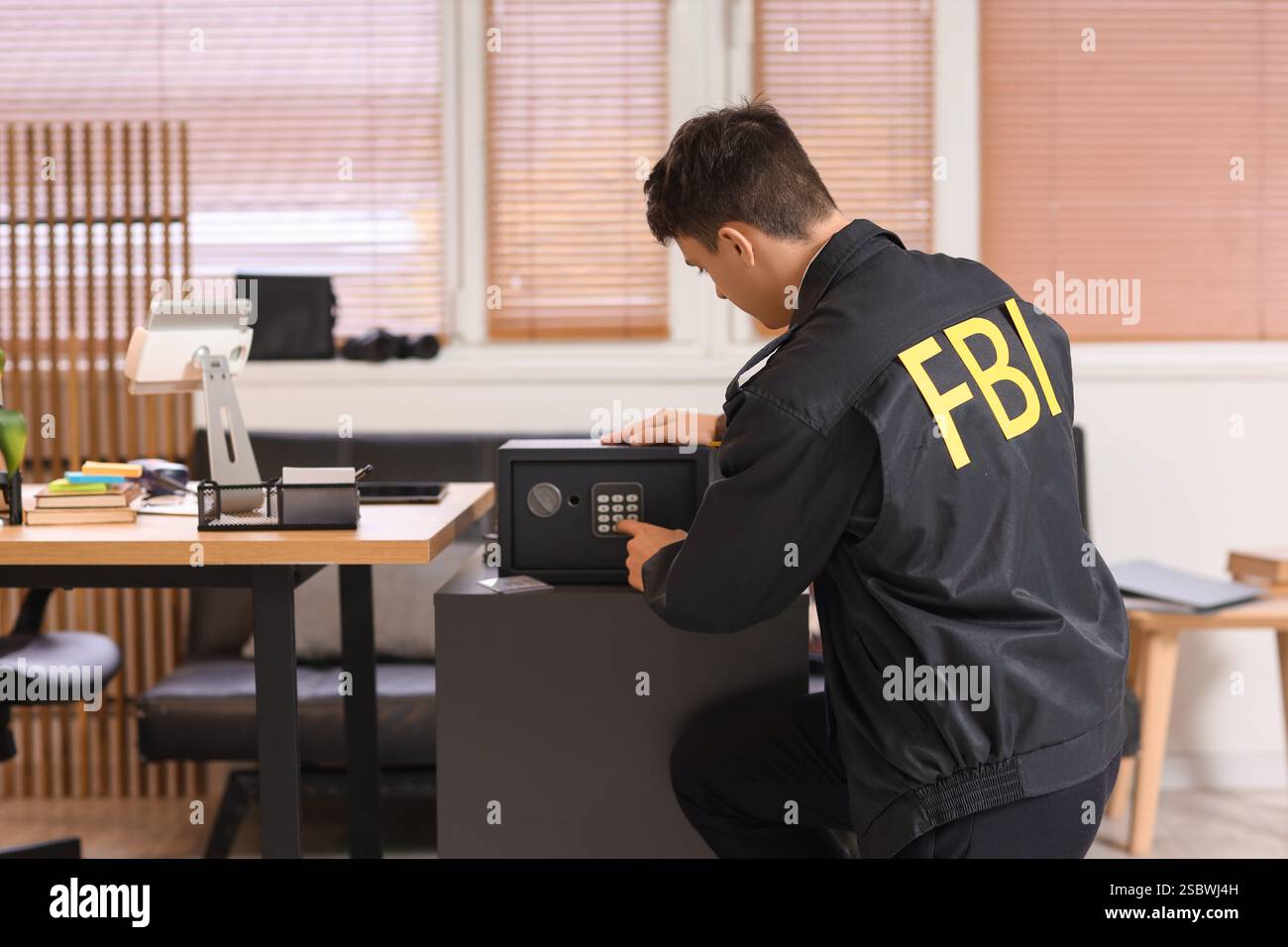 Male FBI agent opening safe in office, back view Stock Photo - Alamy