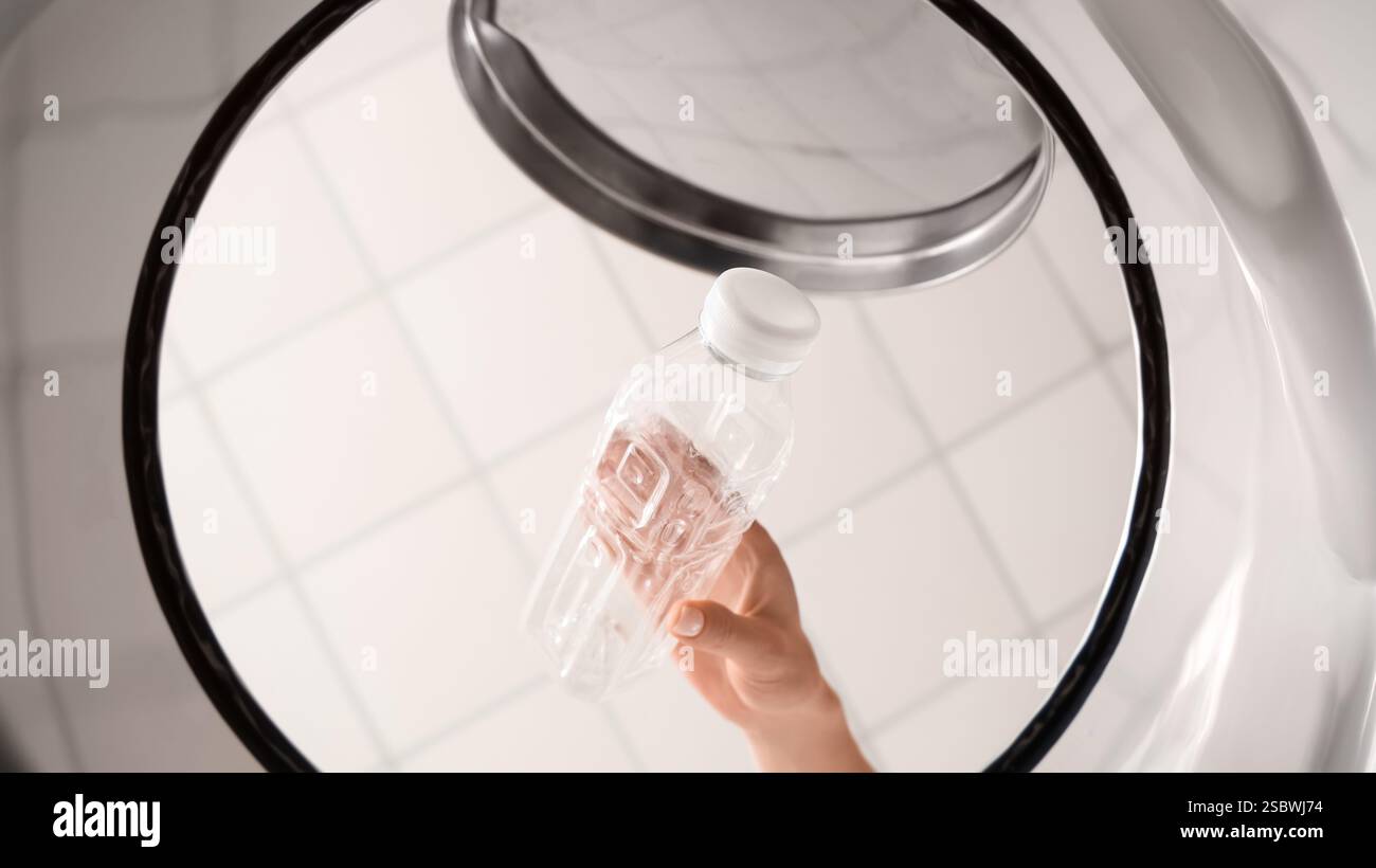 Woman throwing plastic bottle into trash bin at home, view from inside ...