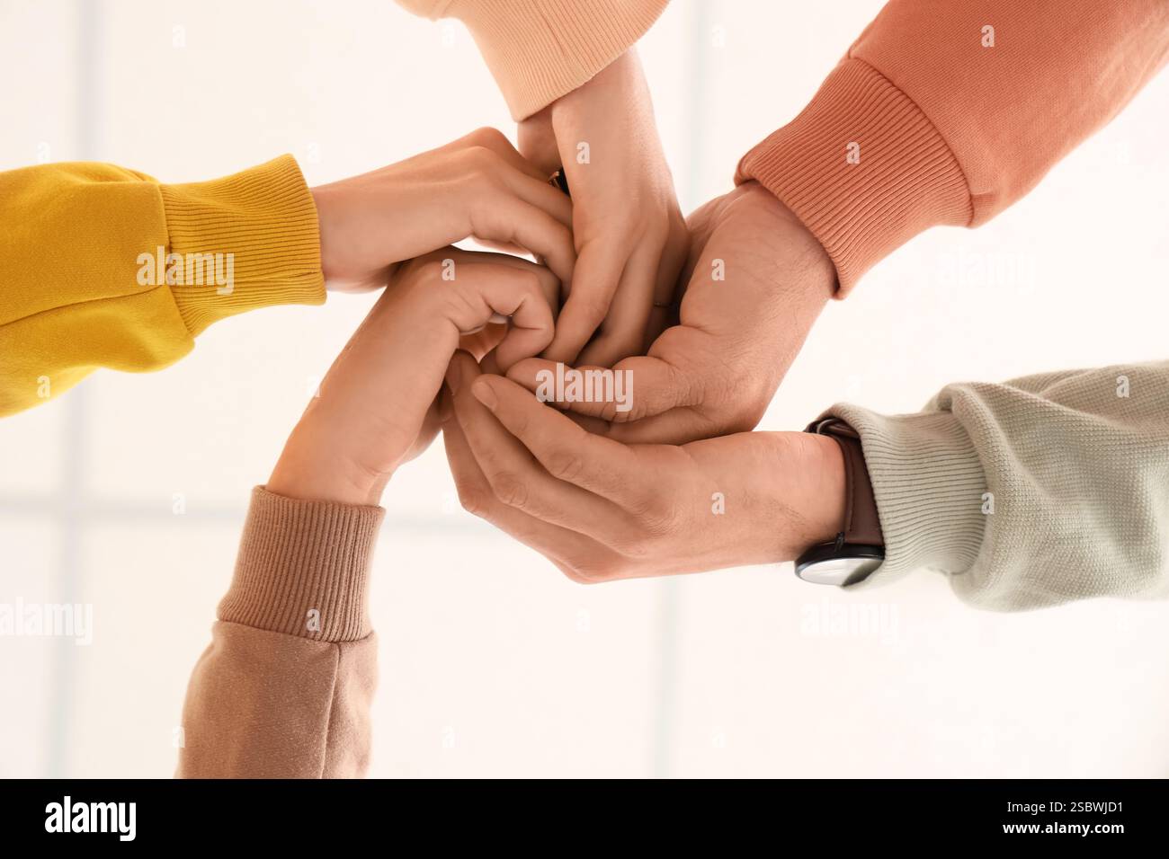 Group of people putting hands together indoors, bottom view Stock Photo ...