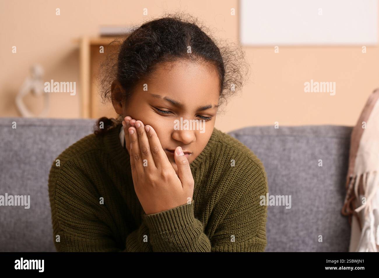 Cute African-American girl suffering from tooth ache at home Stock ...