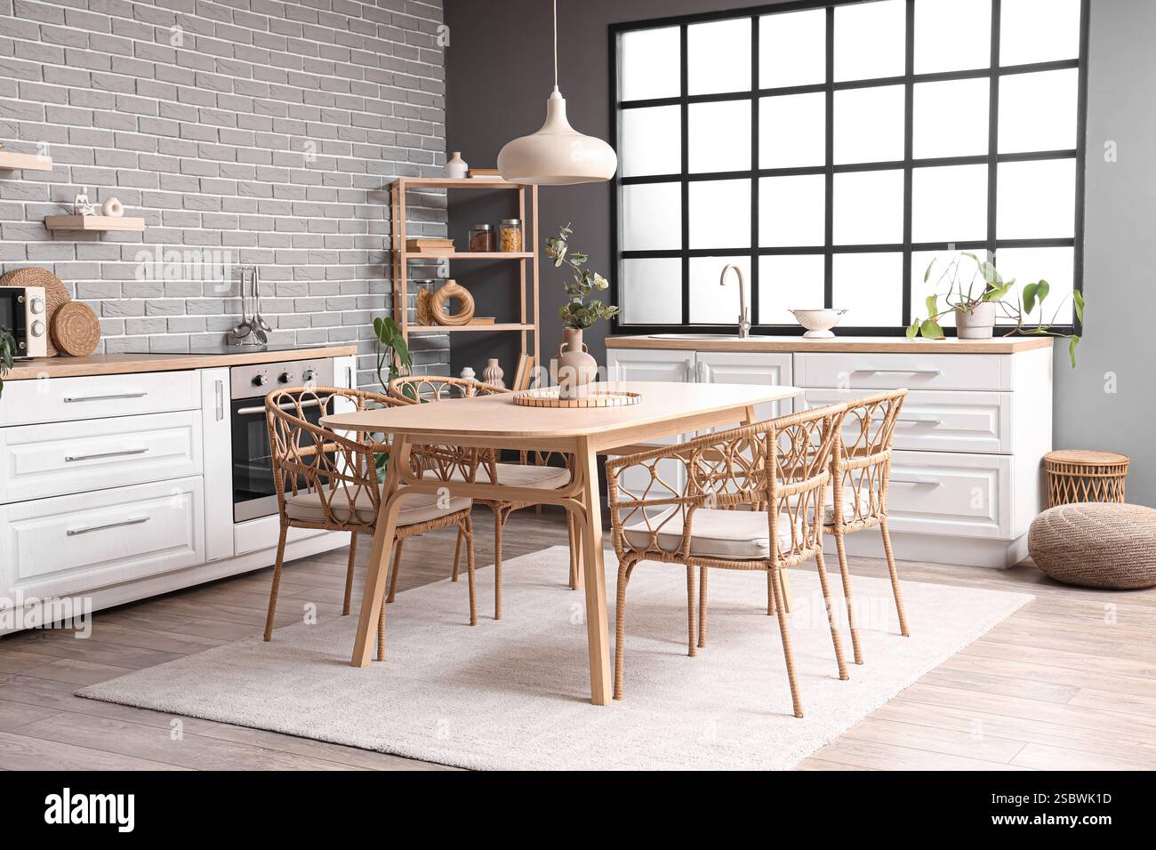 Interior of modern kitchen with dining table, counters and shelf unit ...