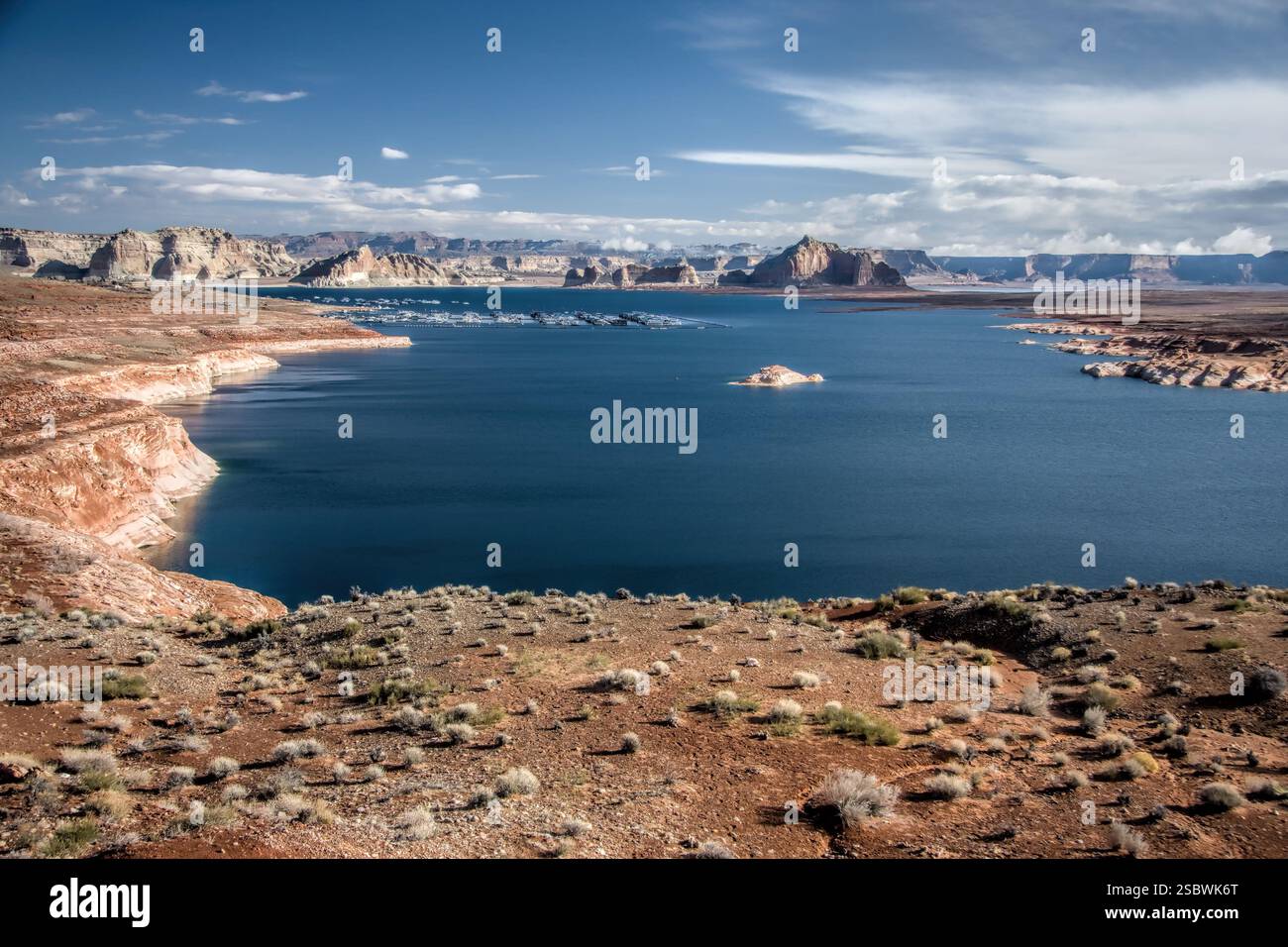 A large body of water with a rocky shoreline. The water is blue and the ...