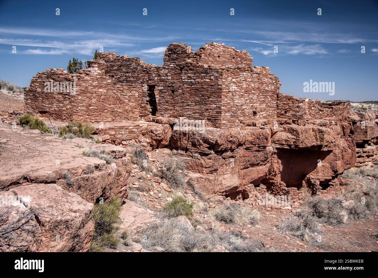 A large rock wall with a small opening. The wall is made of bricks. The ...