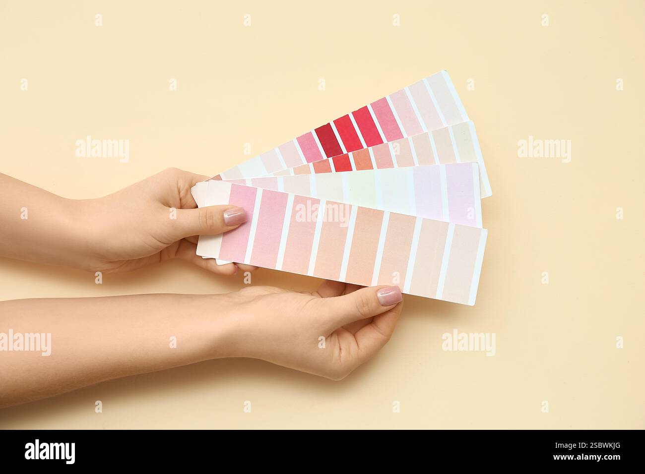 Female hands with different paint color palettes on color background ...