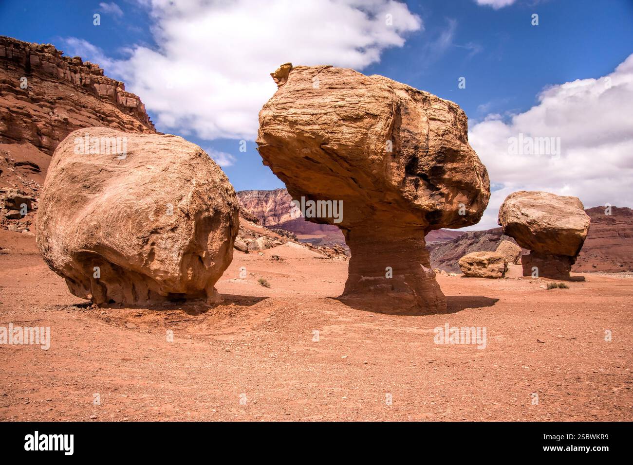 Three large rocks are in the desert. One is on the left, one is in the ...