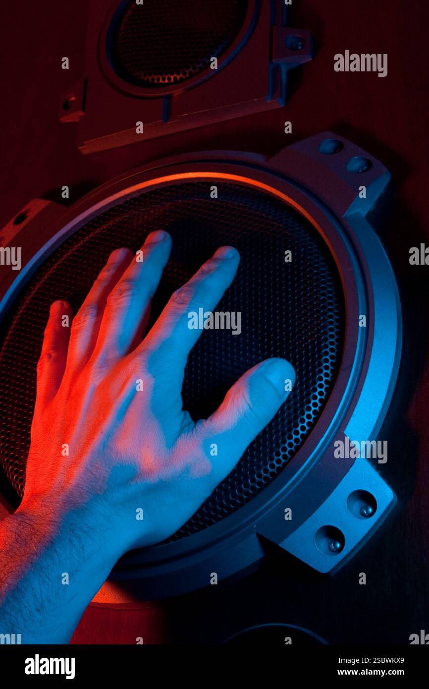 hand covers the speaker in colored light Stock Photo - Alamy